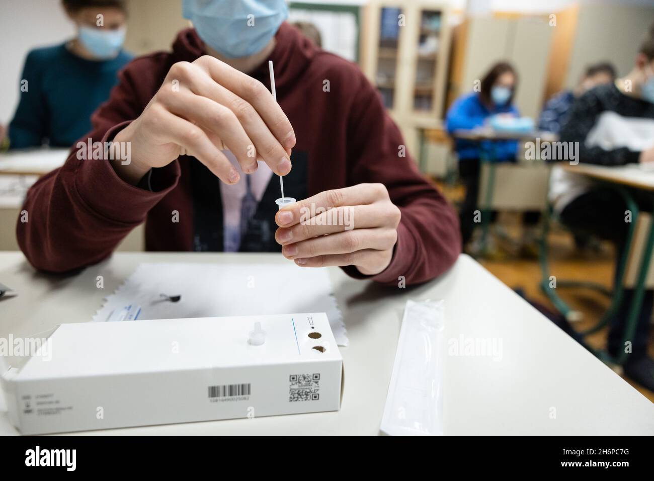 A student self-tests with a rapid COVID-19 antigen self-test kit in a ...