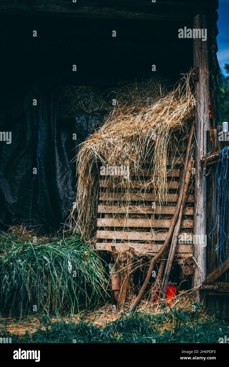 Vertical closeup of a barn with grass and harvested wheat piles Stock ...