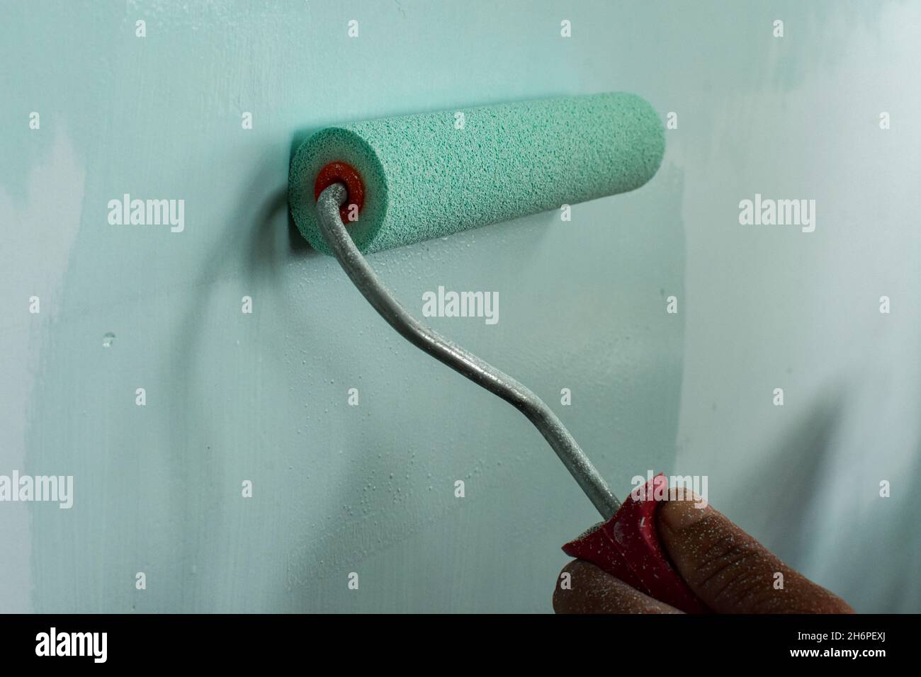Hand painting wall with roll and brush Stock Photo - Alamy