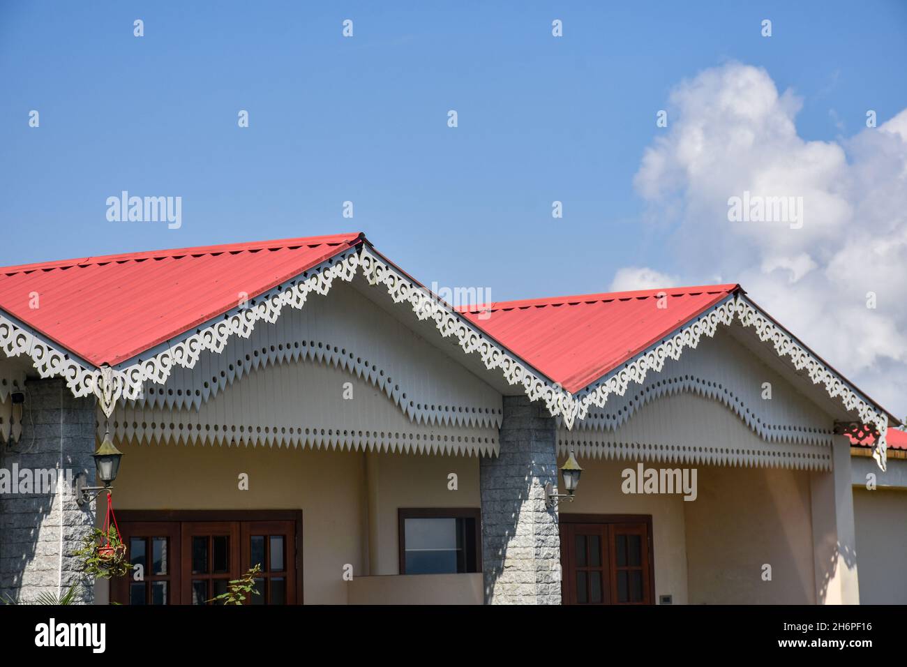 Beautiful red alpine metallic roof and blue cloudy sky Stock Photo - Alamy