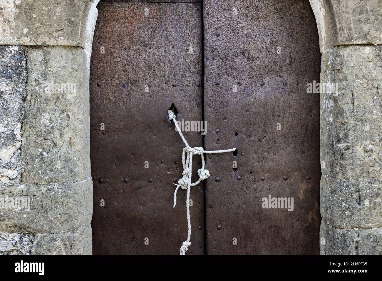 Old forged rusty metal door tied and secured with a rope Stock Photo ...
