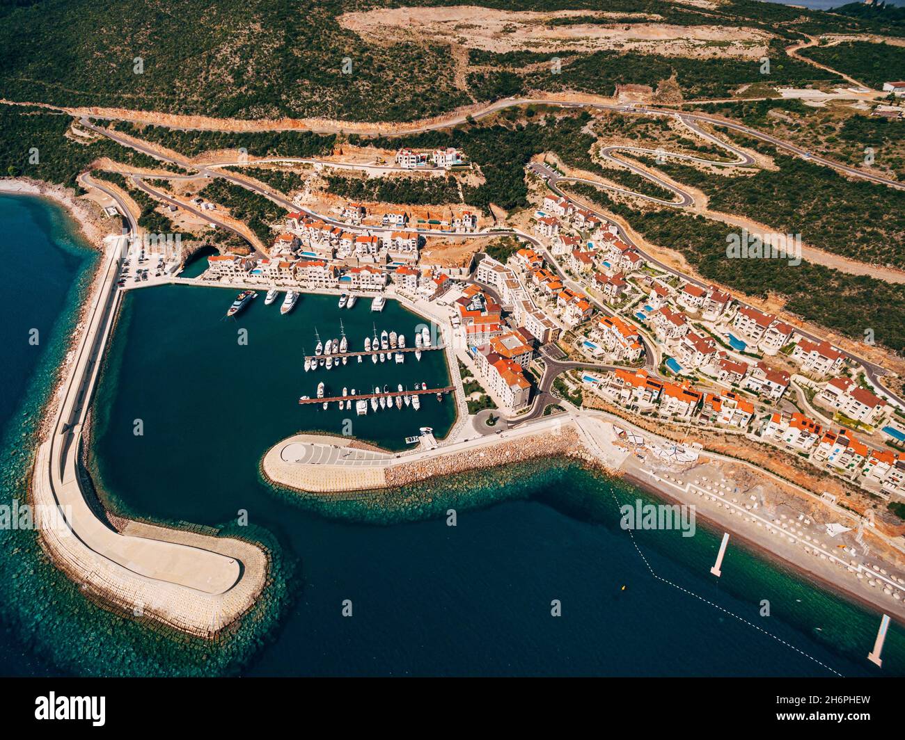 Aerial view of Lustica Bay residential complex with pier and yachts ...