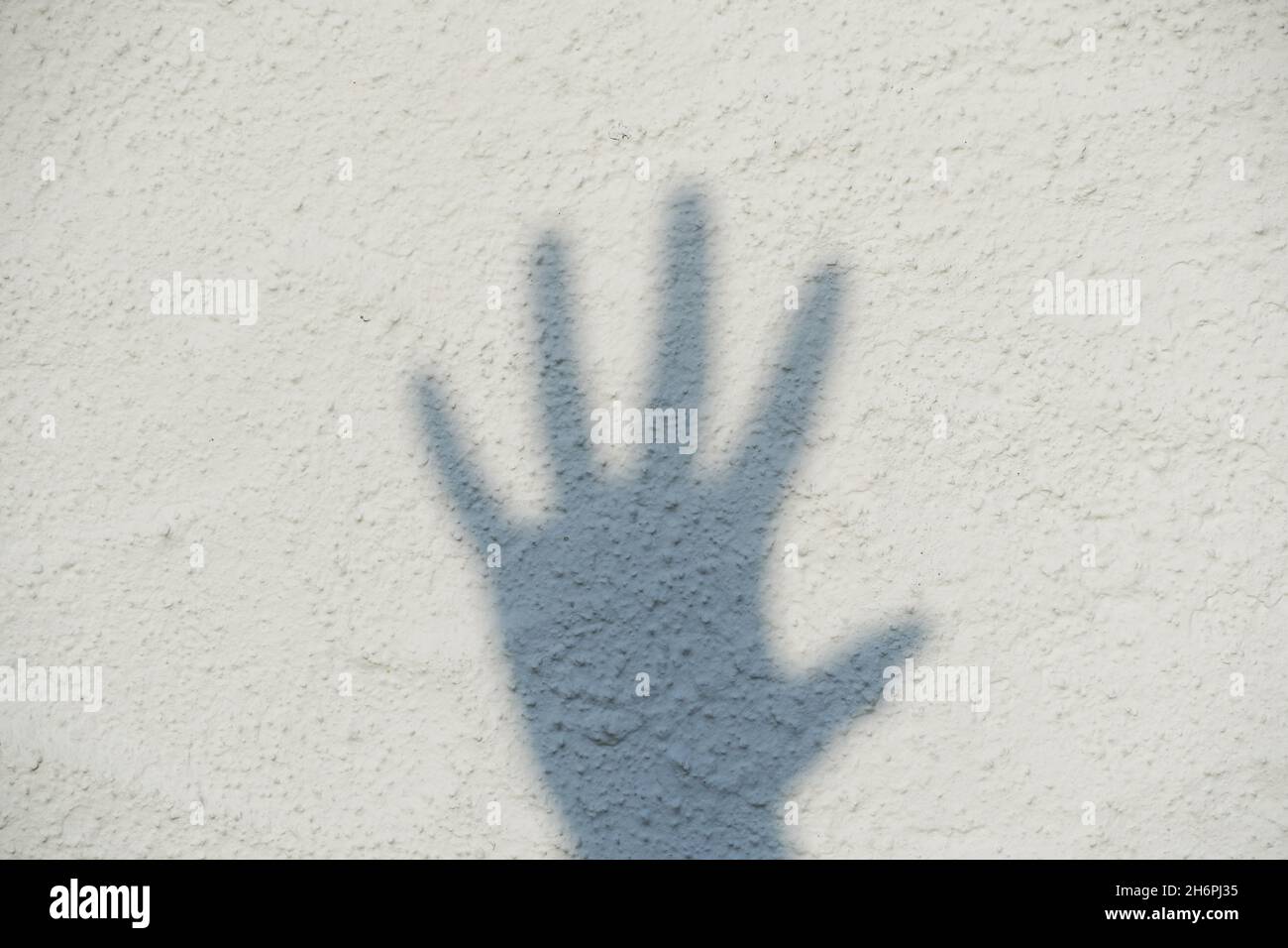 Shadow of a hand on a white wall. Five fingers. Stop Stock Photo - Alamy