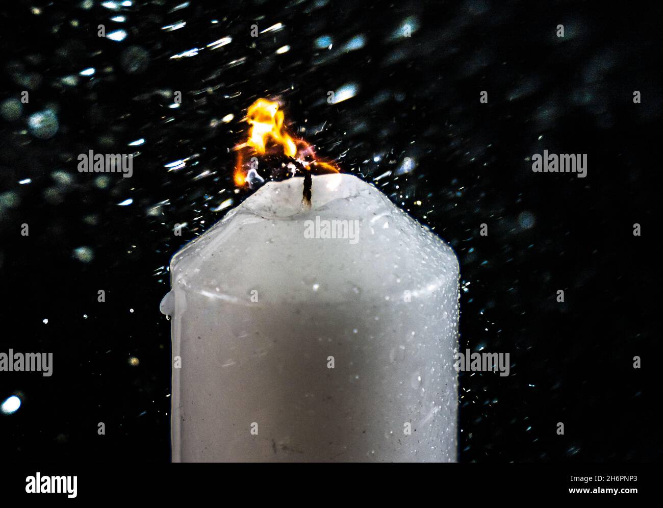 Process of a lit candle getting blown out by water against a black ...