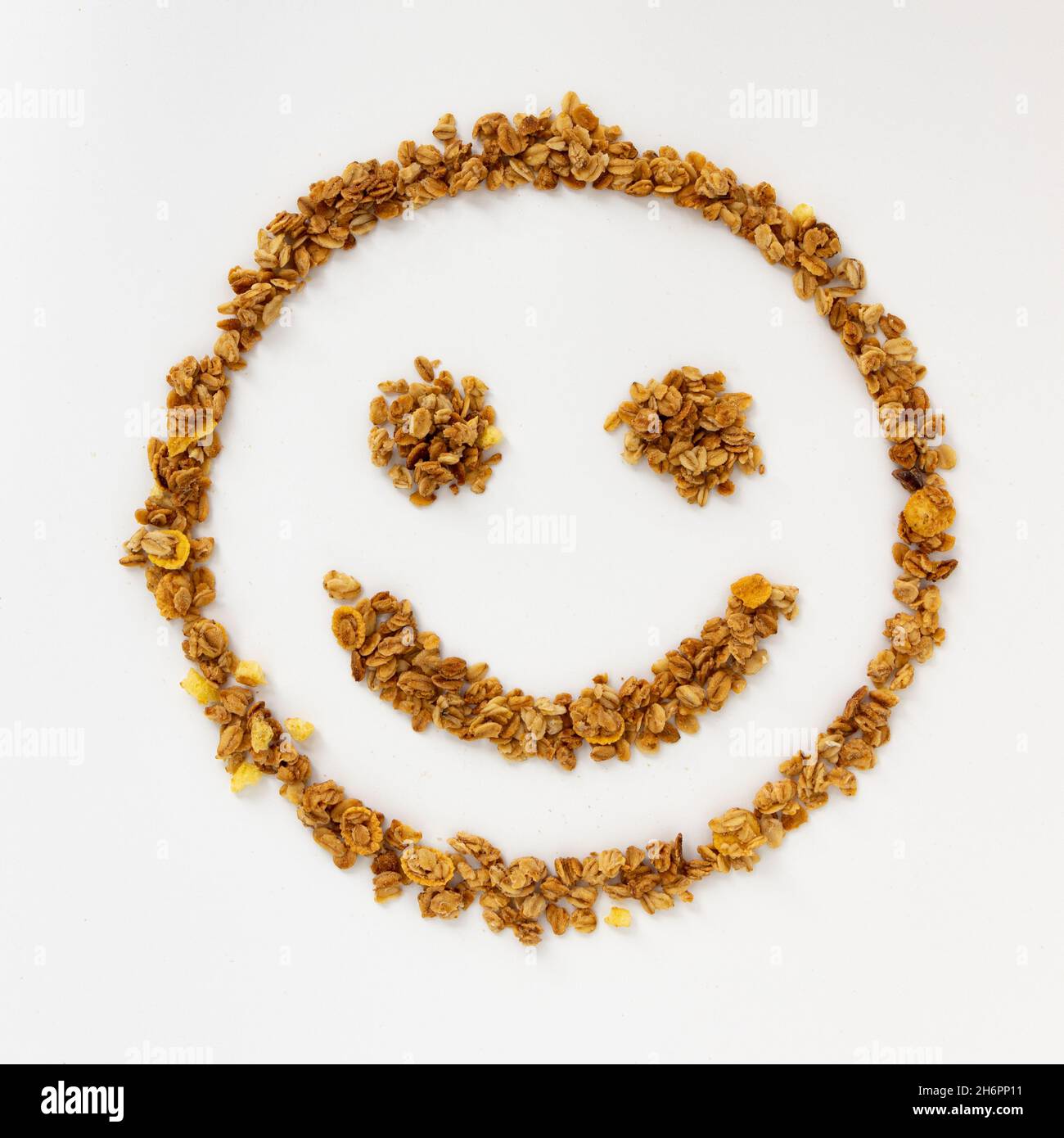 crunchy granola breakfast in the shape of smiling face on white ...