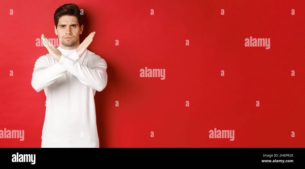 Image of serious and angry man in white sweater, express storng ...