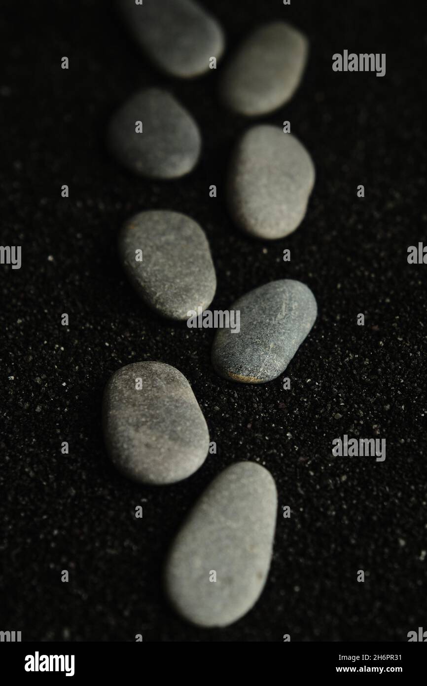 small sea pebbles are laid out on a black background Stock Photo - Alamy