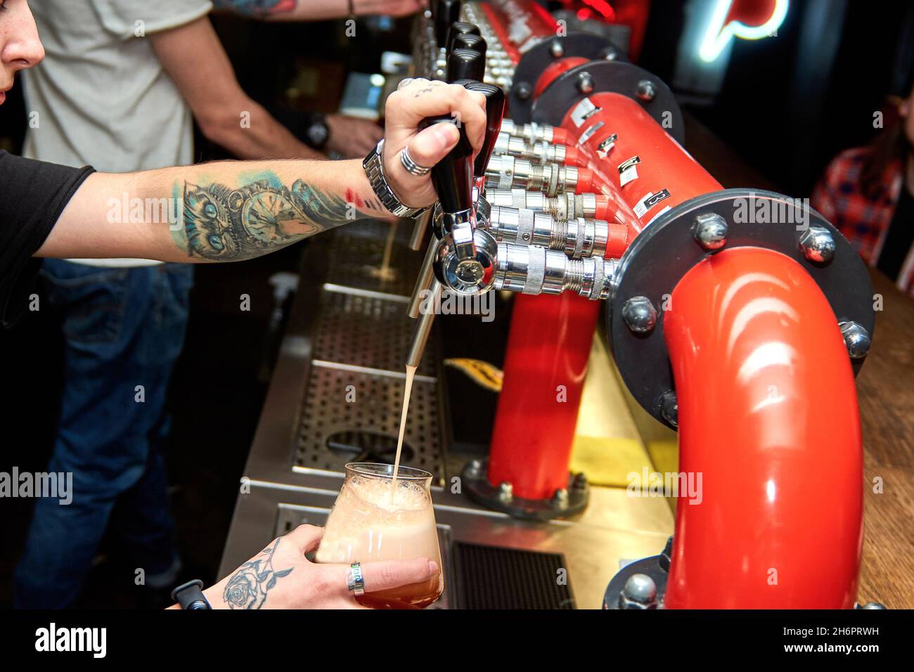 Hand of bartender pouring a large lager beer in tap. Pouring beer for ...