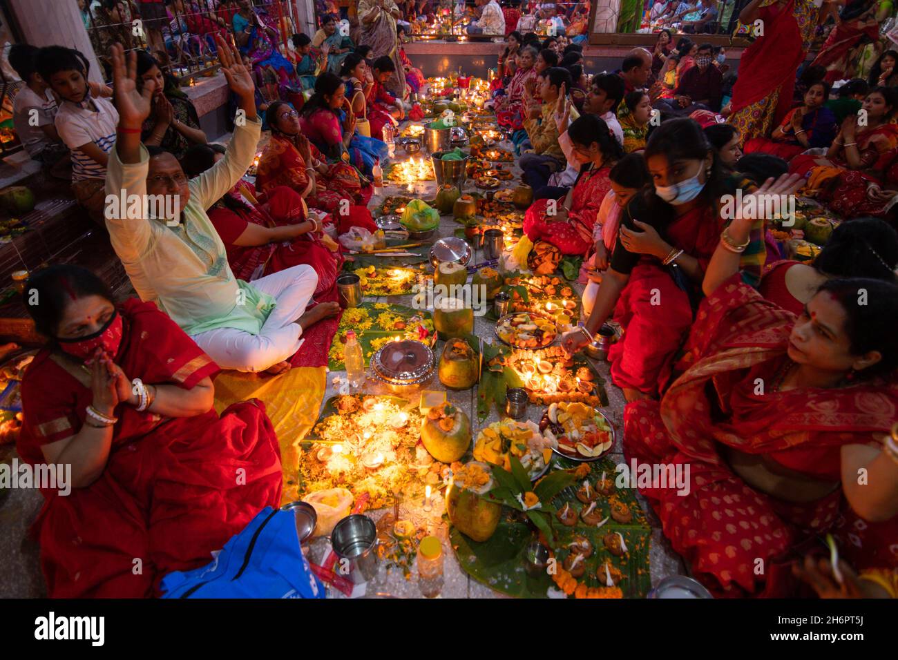 Hindu devotees sit with Prodip (lights) and pray to God for the welfare ...