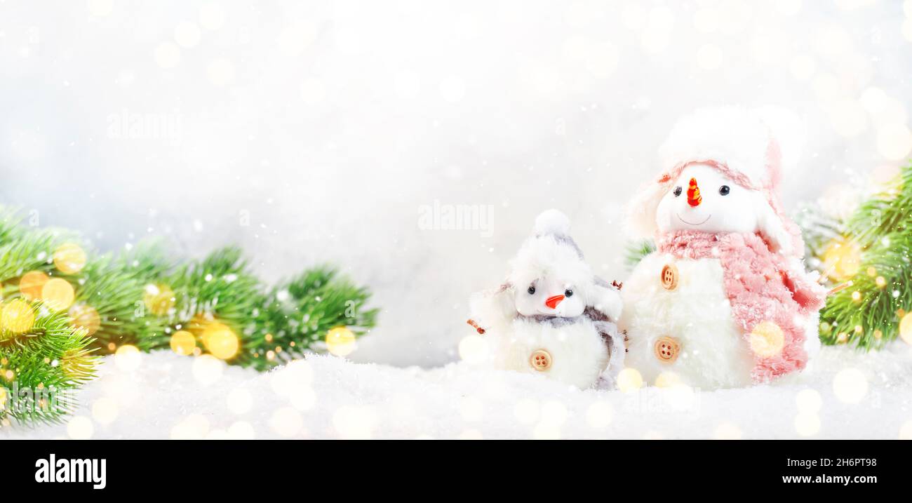 Christmas snow composition with two cute snowmen in hats and scarves in ...