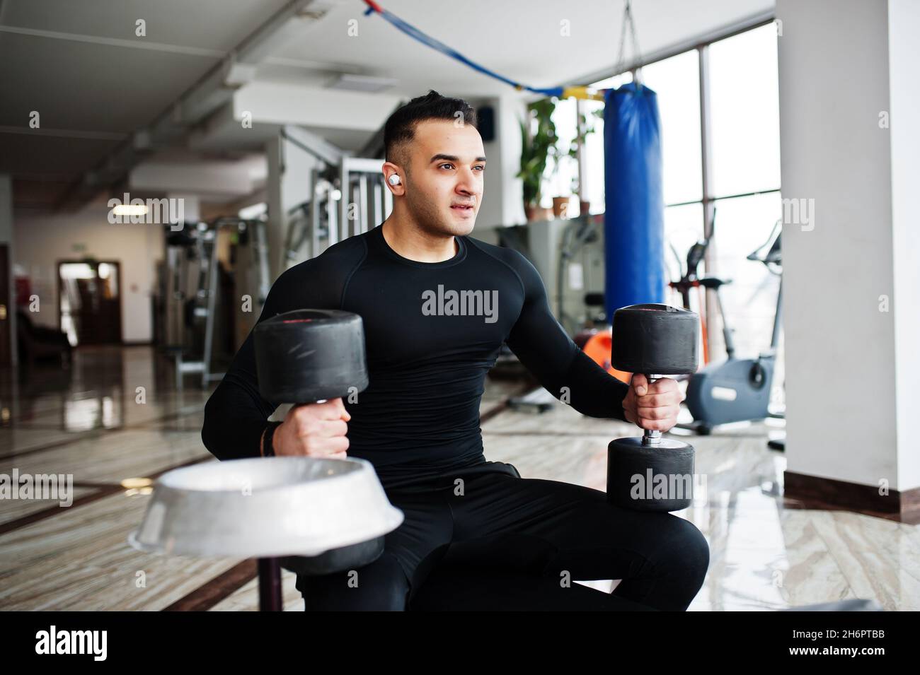Muscular arab man training with dumbbells in modern gym Stock Photo - Alamy