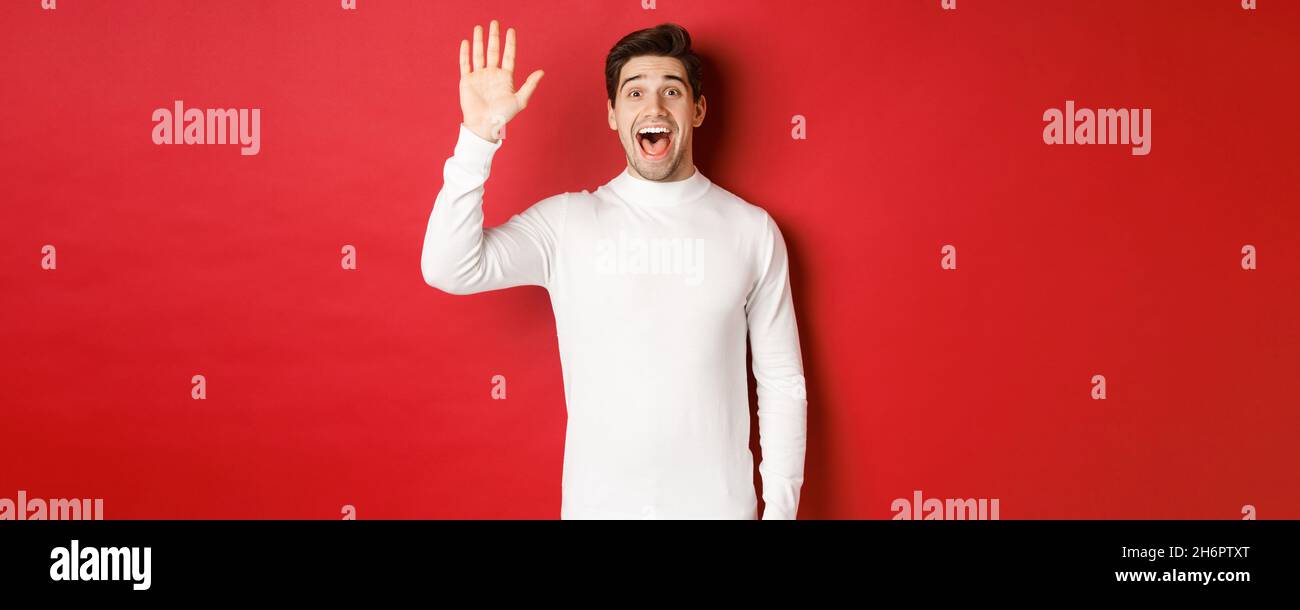 Image of happy and friendly young man saying hello, waving hand to ...