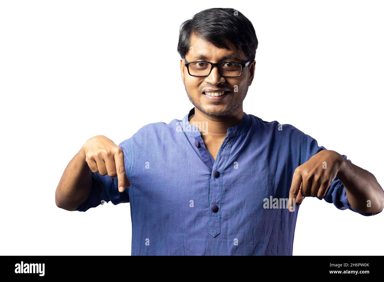 A young Indian male in blue dress pointing downwards with both hands on ...