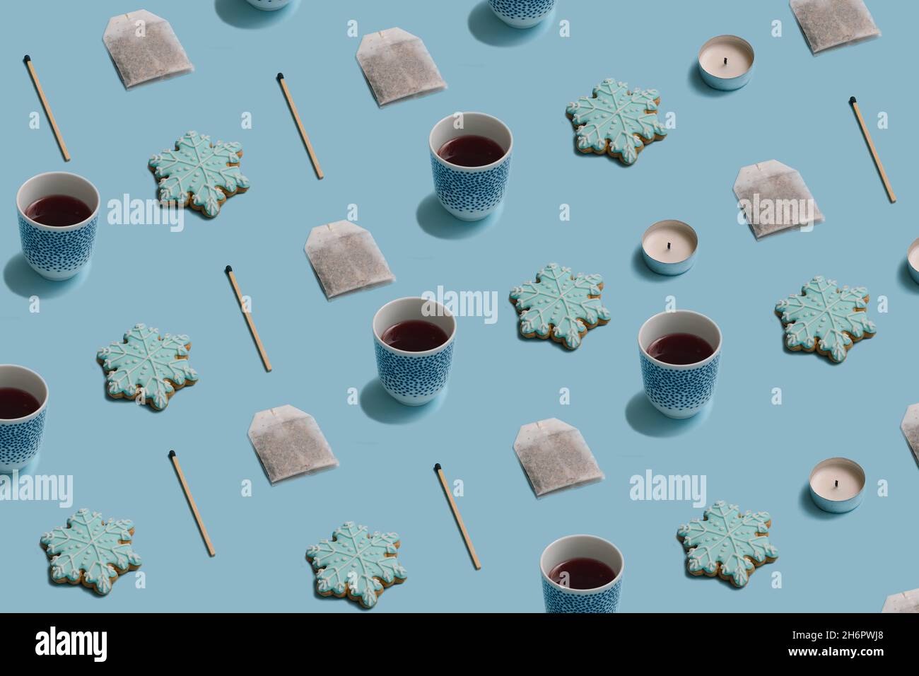 Winter pattern made of teabag, cup, matches and snowflake cookie and ...