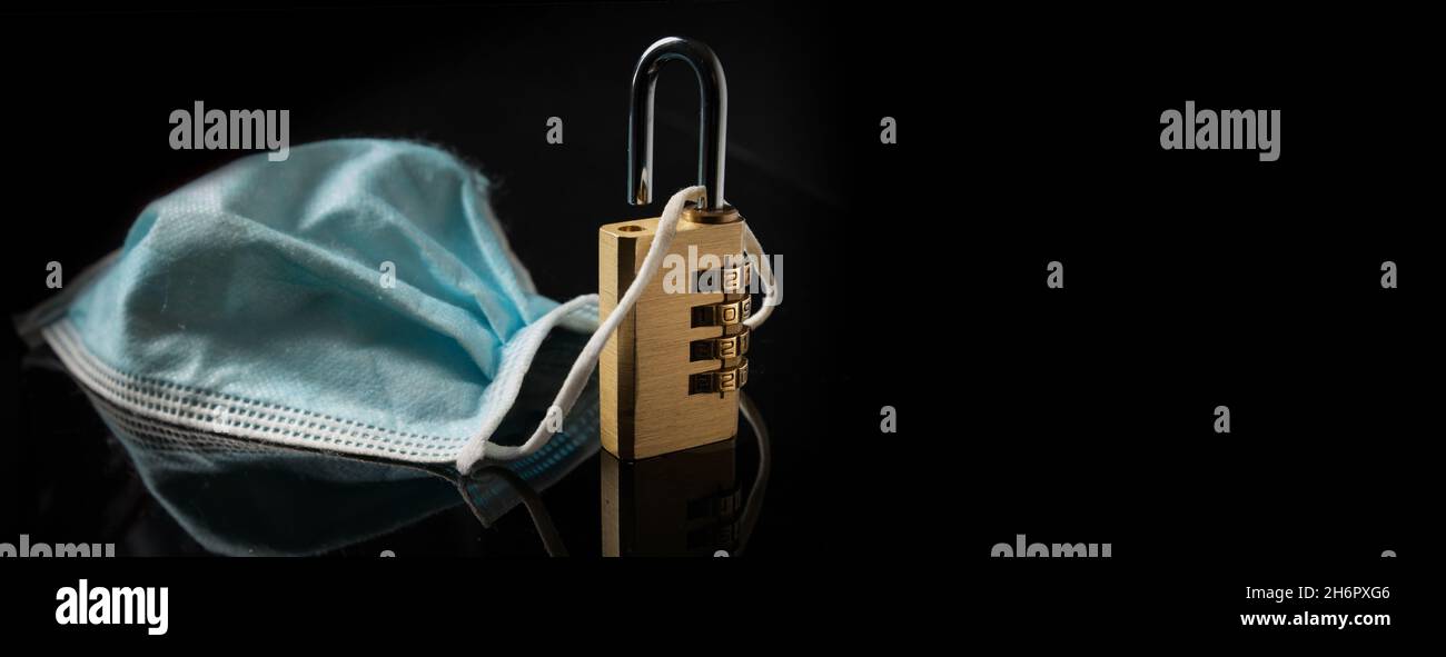 Mask and a combination lock on a black background with copy space ...
