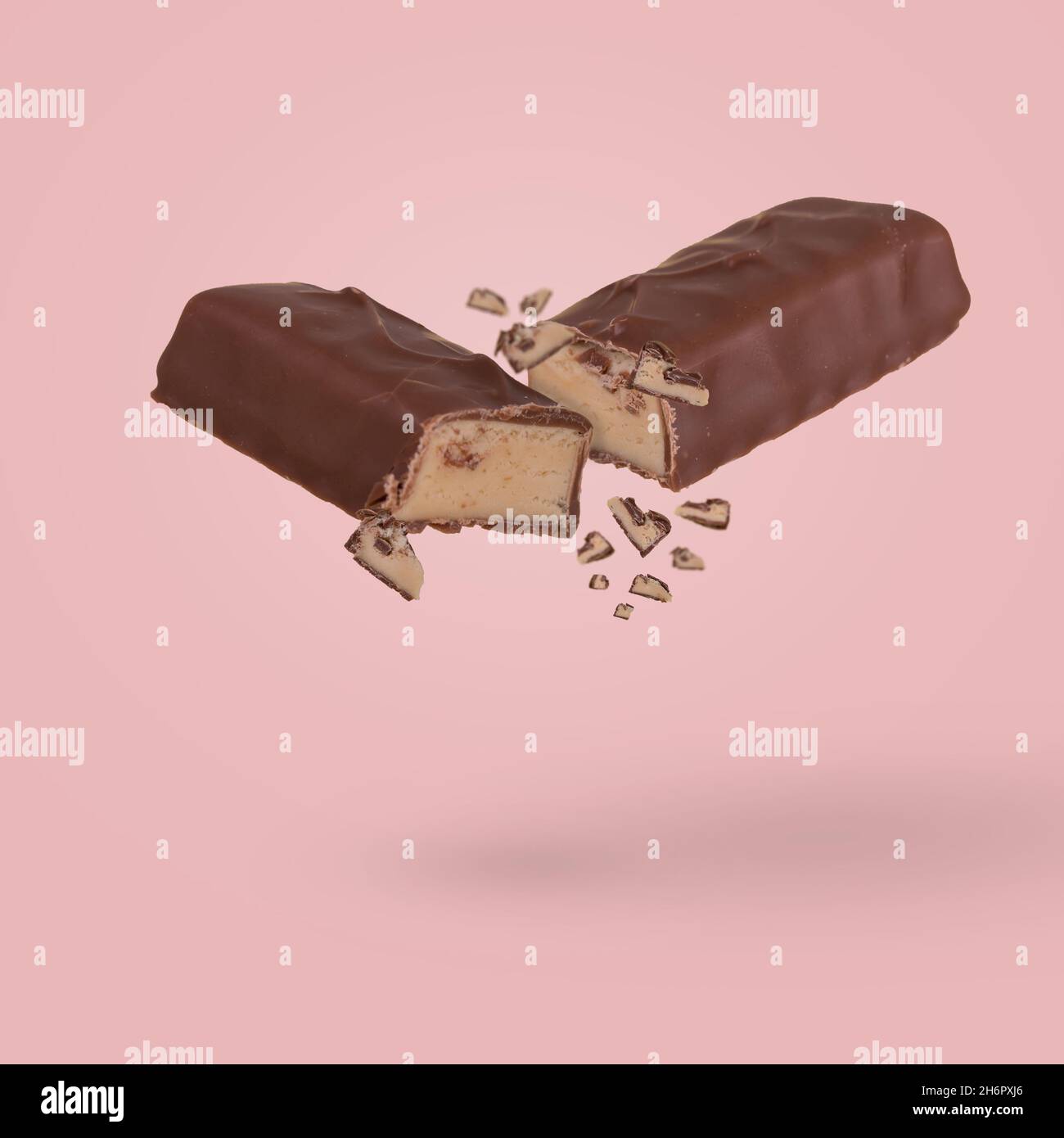 Cracked chocolate bar with milk filling floating in the air isolated on ...