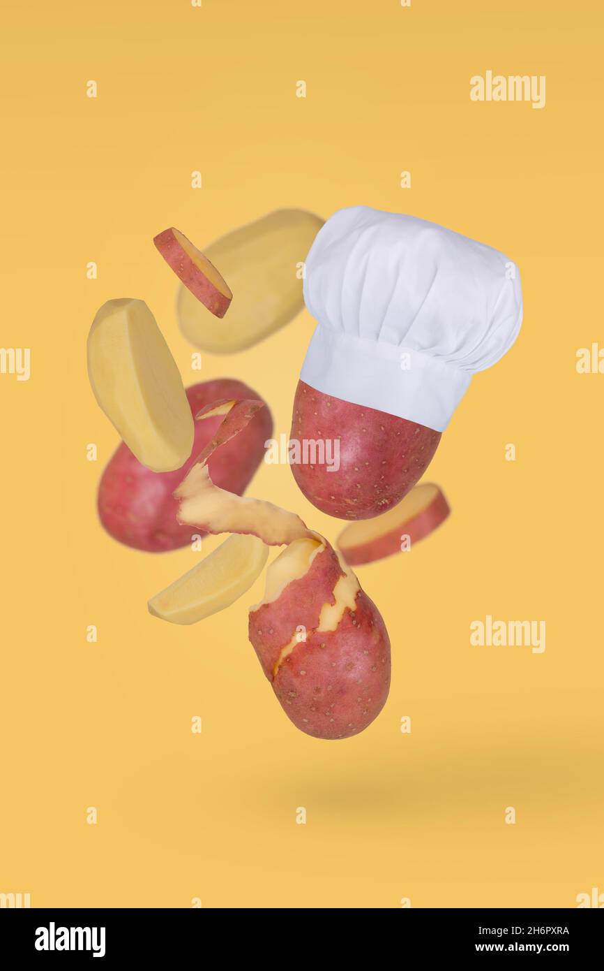 Fresh raw sliced potato flying in air isolated on yellow background ...