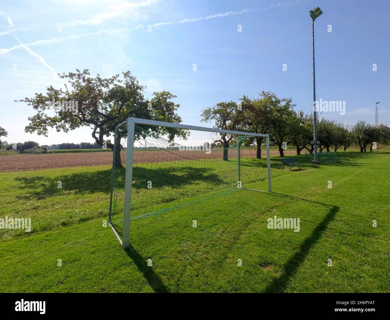 Soccer goal on a field with trees in the background on a sunny day ...