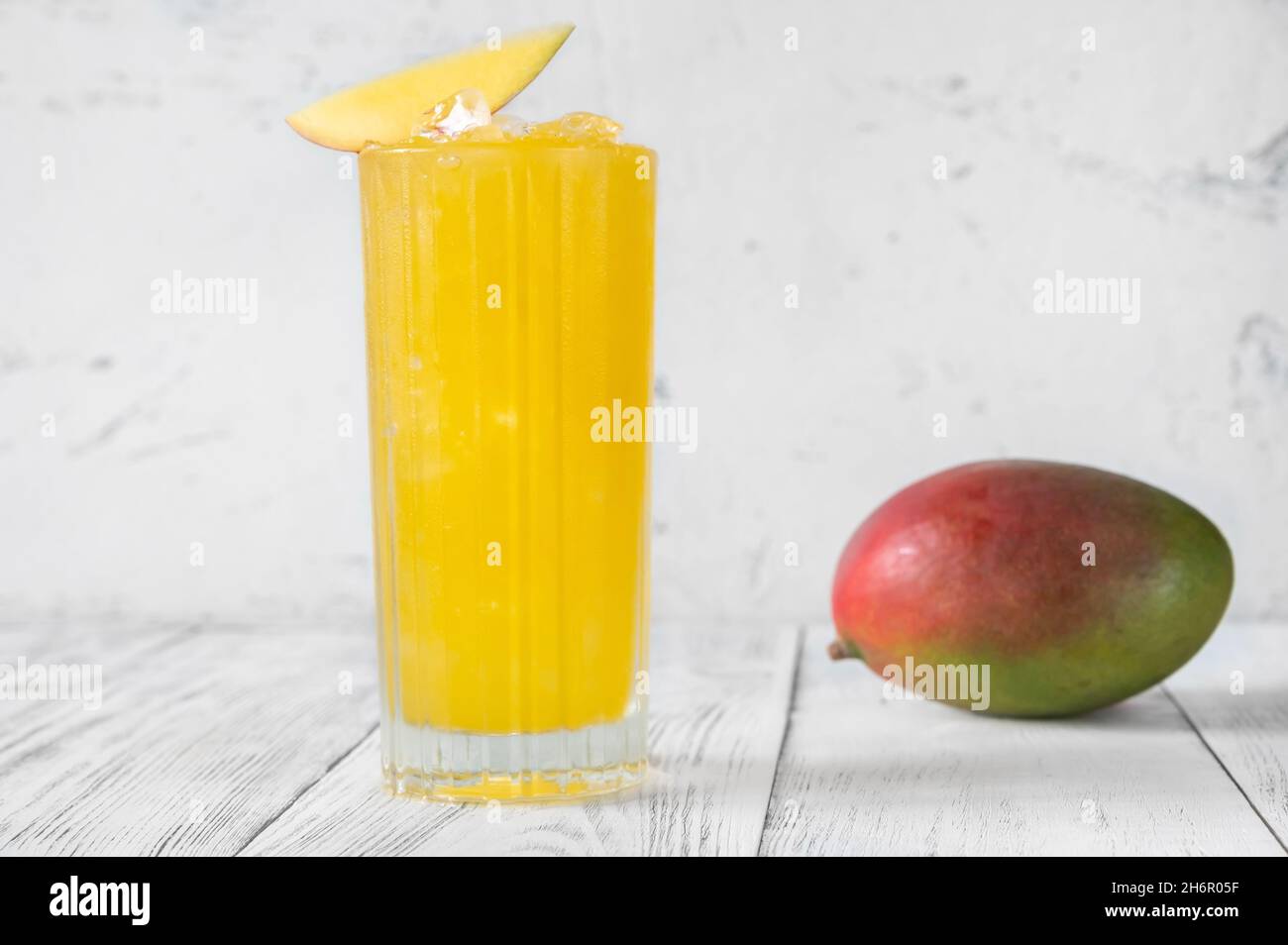 Glass of Mango Punch cocktail garnished with mango slice Stock Photo ...