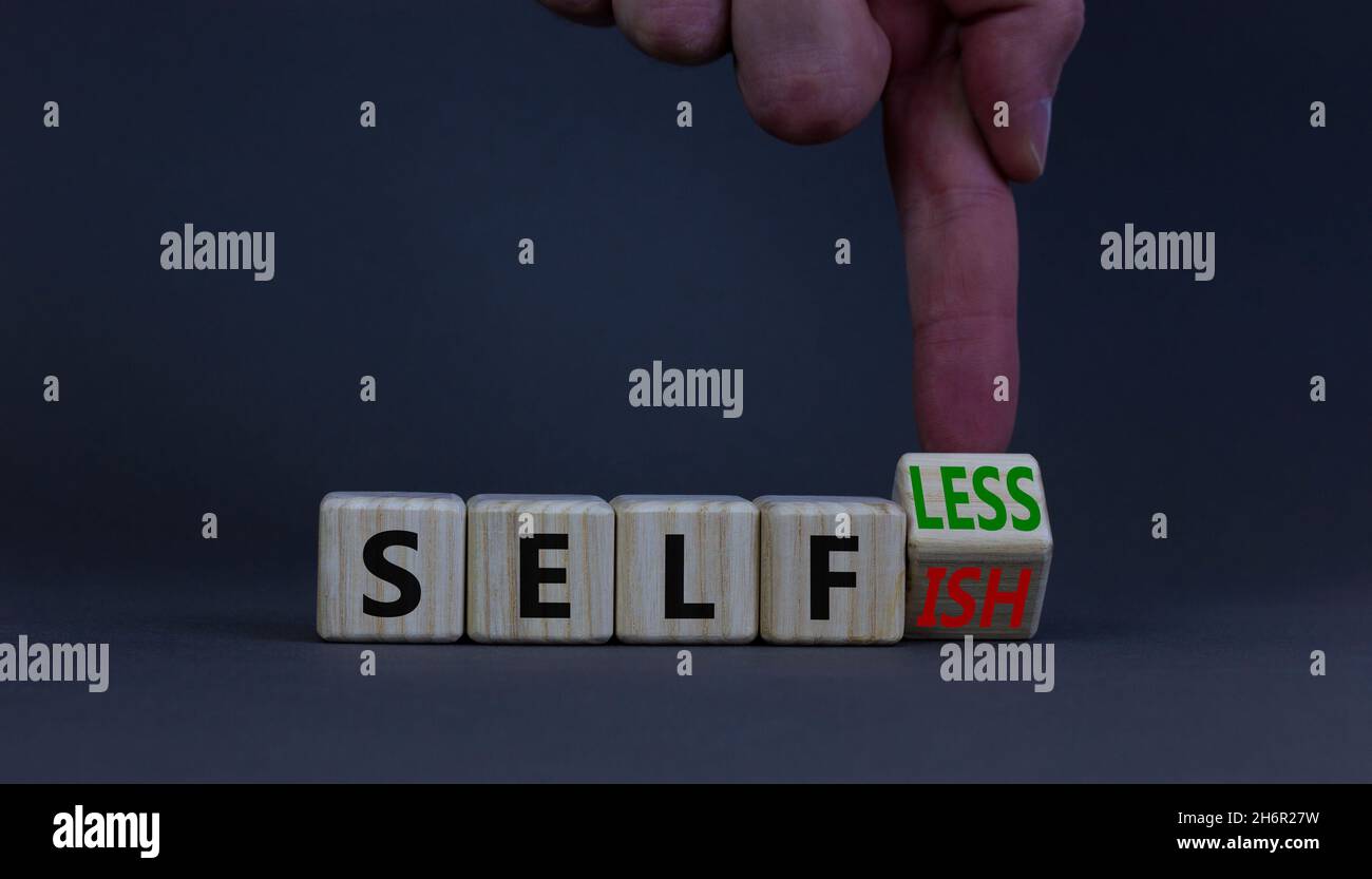 Selfish or selfless symbol. Businessman turns a wooden cube and changes ...