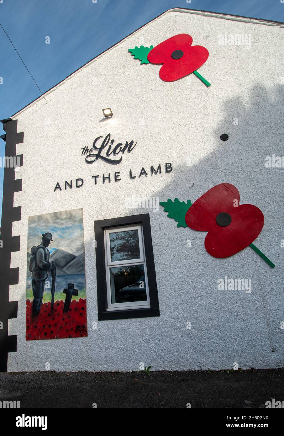 Remembrance poppies and painting on a pub wall, the Lion and the Lamb ...