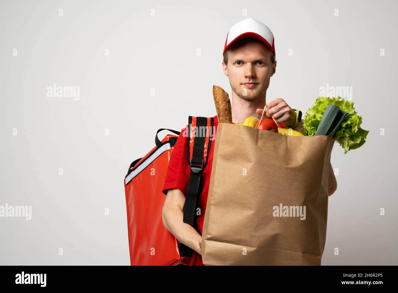 Delivery of food packages. Man with a thermal bag holding a paper bag ...