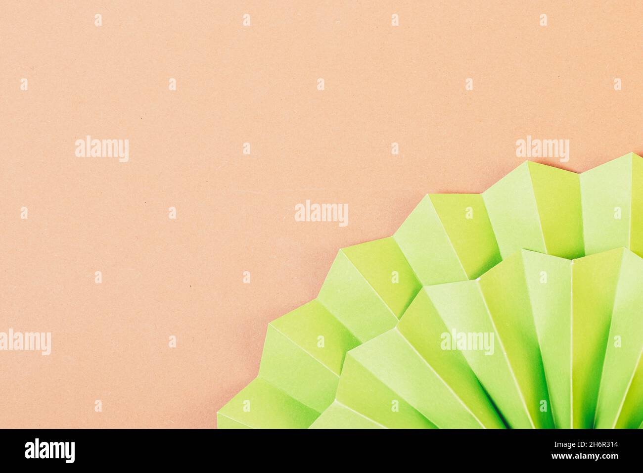 Round origami green paper decorations on brown background with copy ...