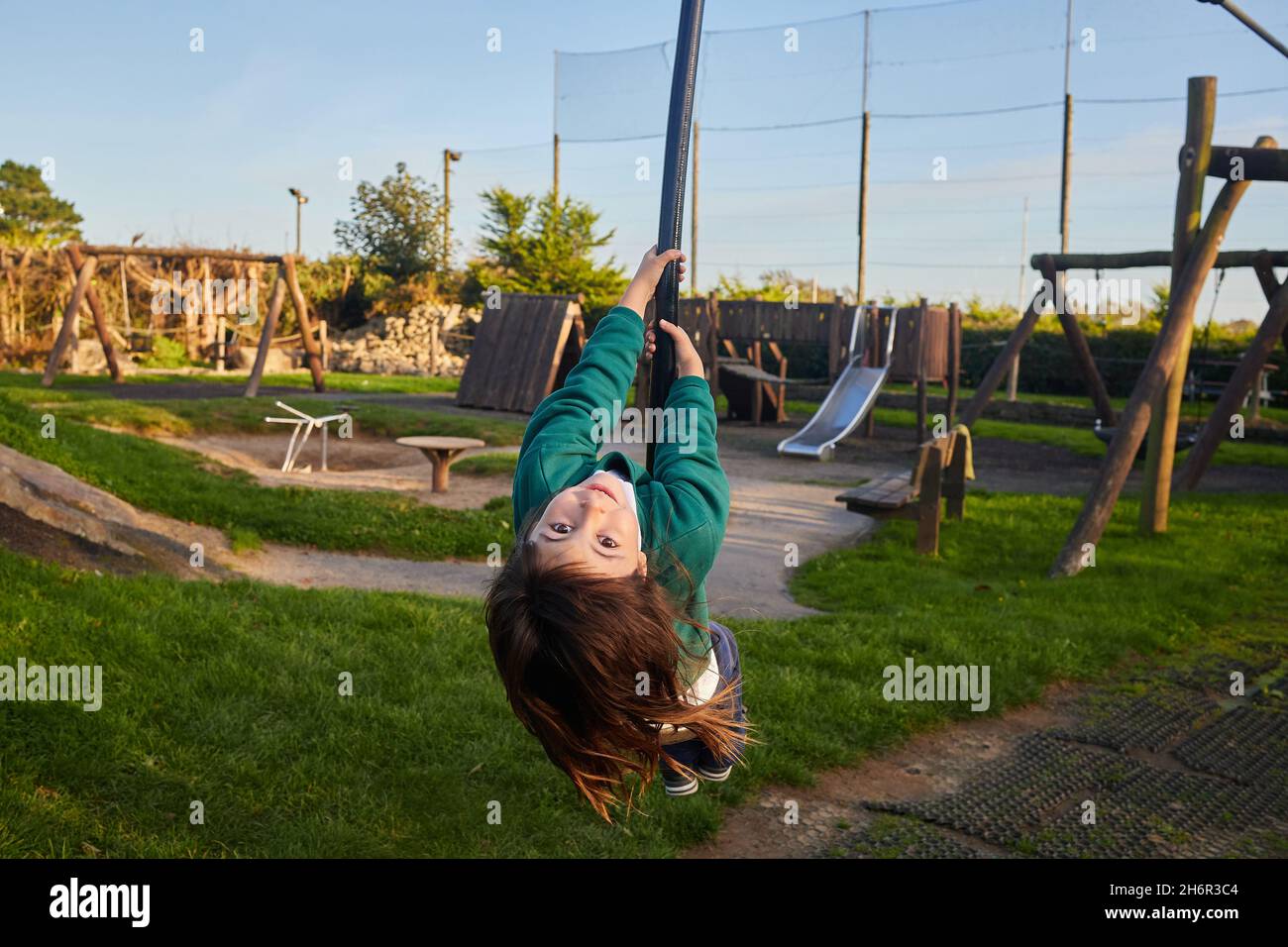school child hanging from a rope in an incredible playground with ...