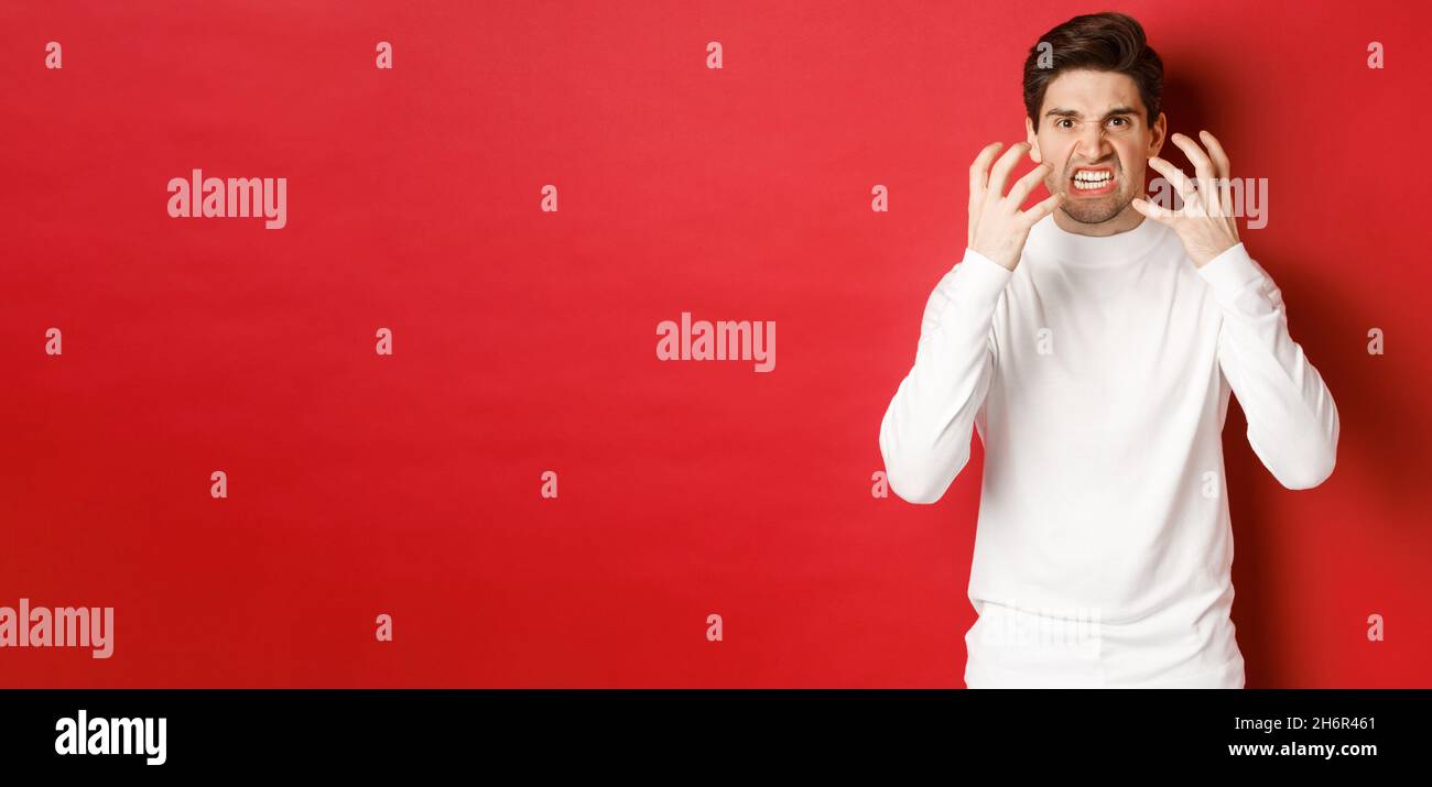 Image of angry and pissed-off man in white sweater, grimacing and ...