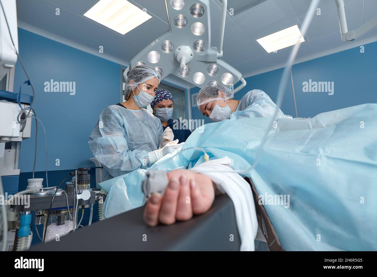 The patient's hand is under the IV with a pulse oximeter on the finger ...