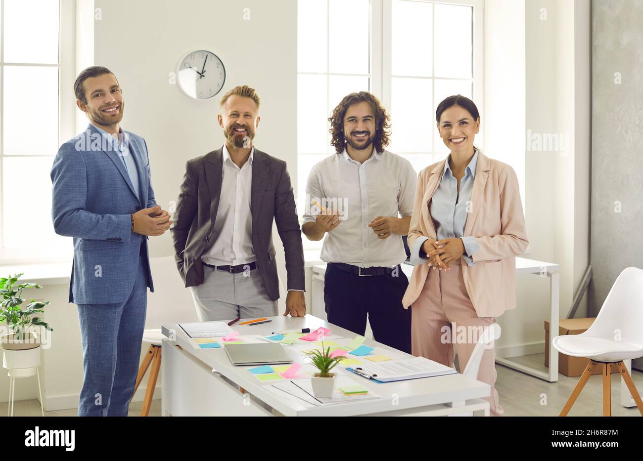 Group portrait of happy creative business people standing by office ...