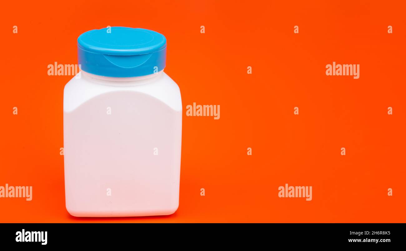 white unbranded pill jar. multivitamin bottle on orange background ...