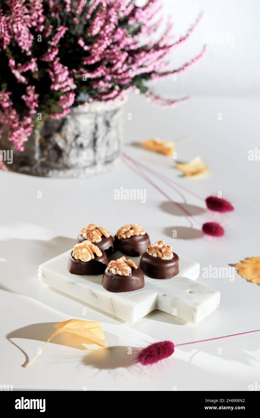 Chocolate pralines with walnut nuts on marble cutting board. Closeup on ...