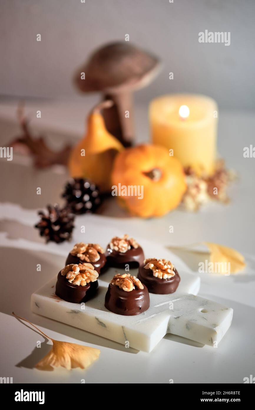 Chocolate pralines with walnut nuts on marble cutting board. Closeup on ...