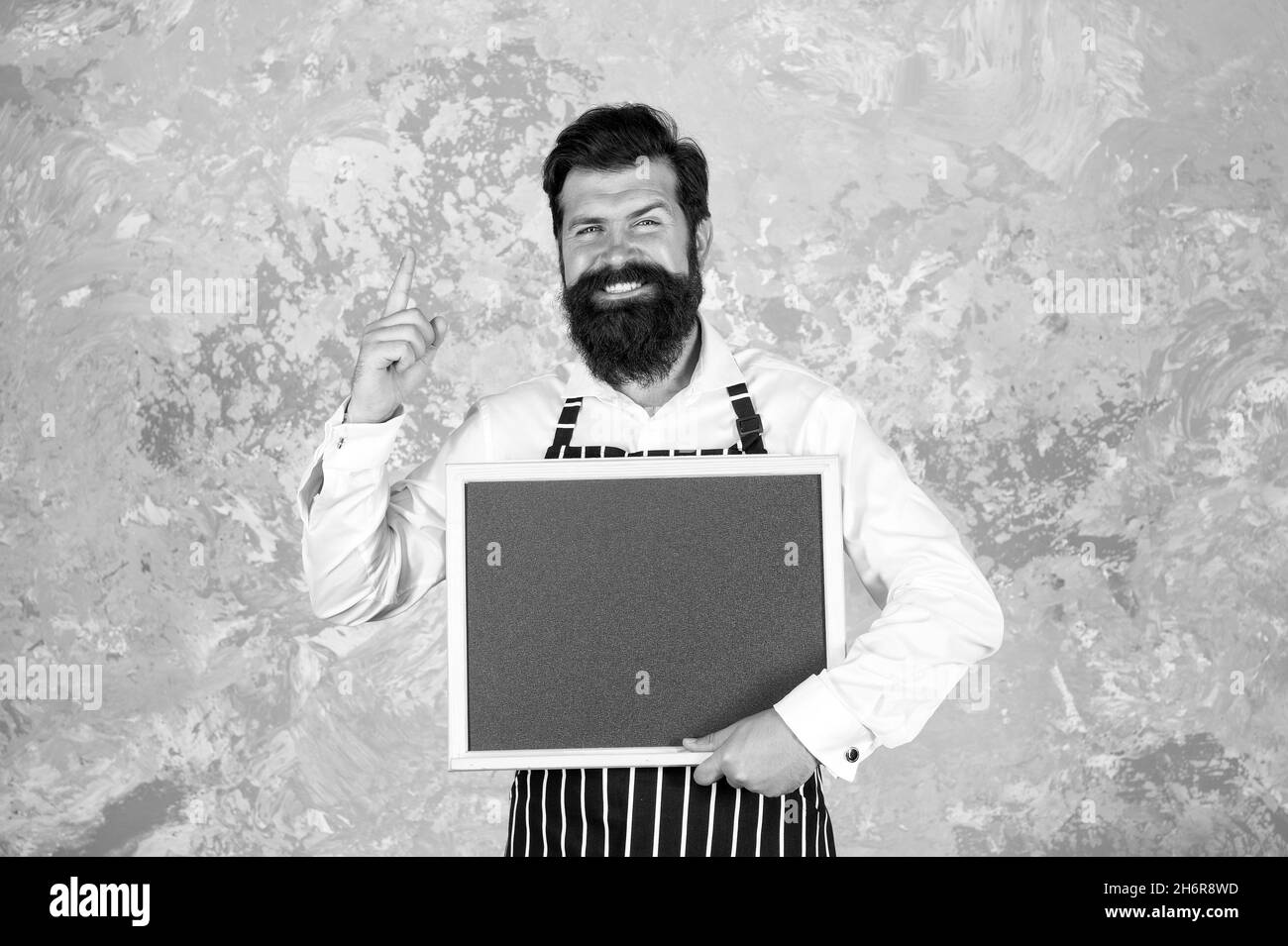 brutal bearded man chef presenting restaurant menu on empty board for ...