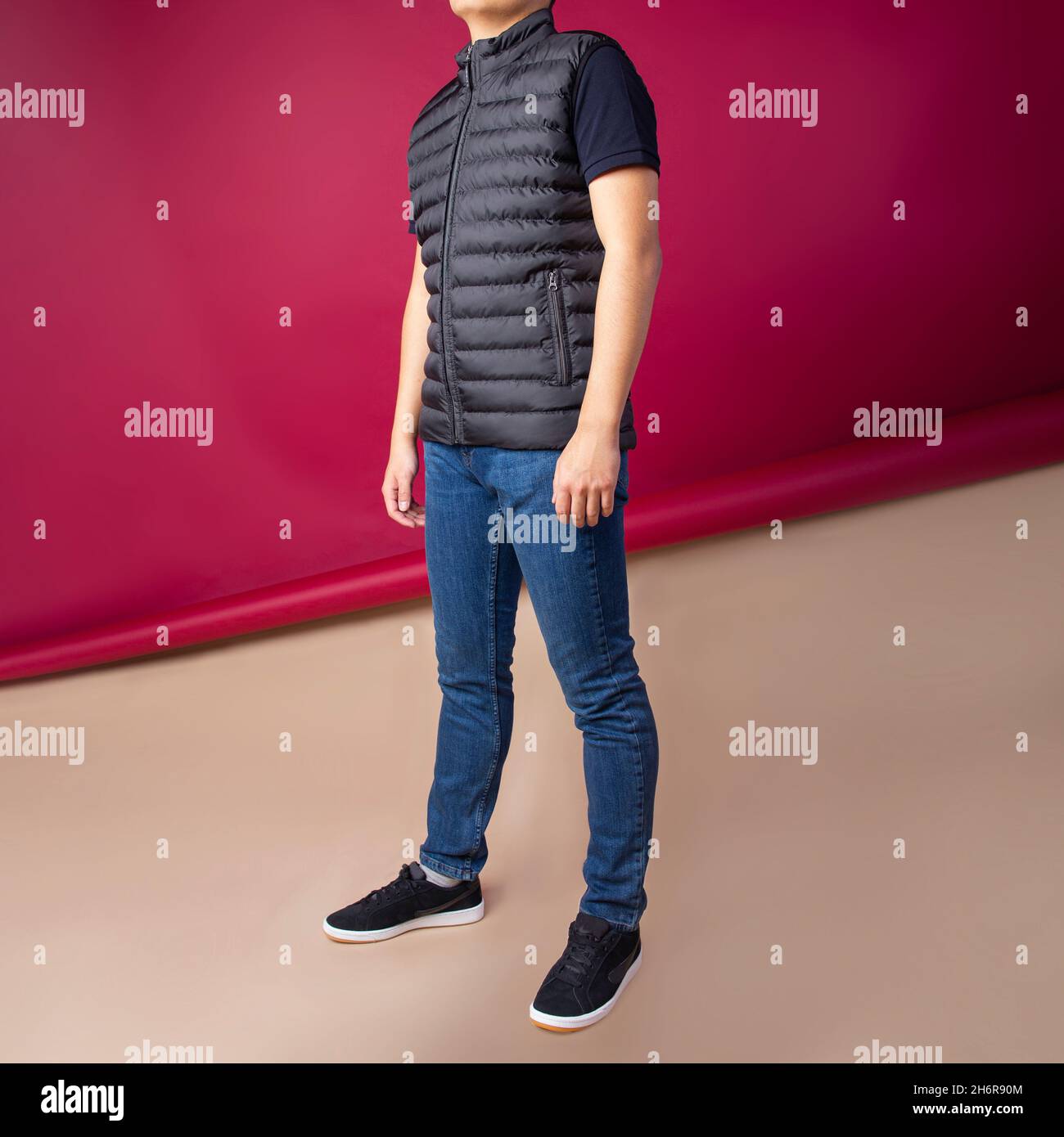 men's legs in jeans on a paper burgundy background. promotional photo ...