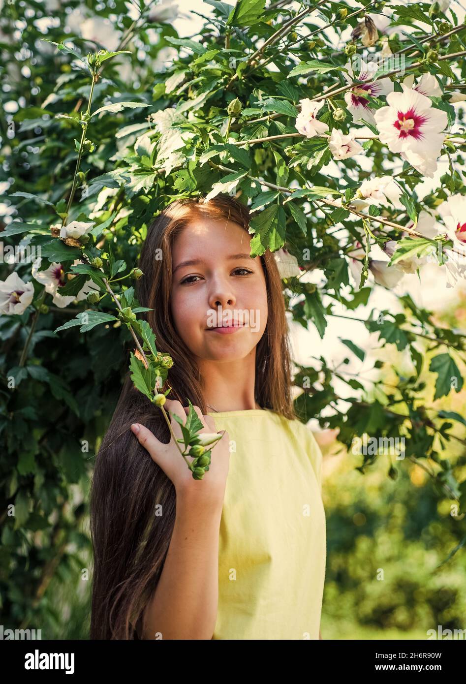 teen girl near blooming hibiscus. kid at blossoming tree. child enjoy ...