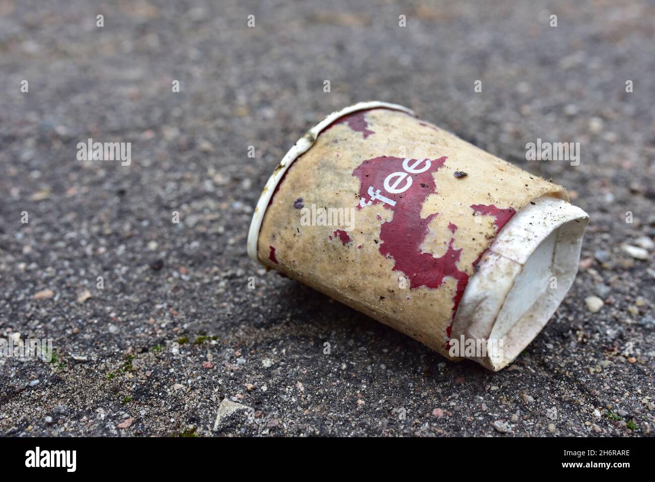 Crumpled a paper coffee cup on asphalt. Discarded disposable coffee cup ...