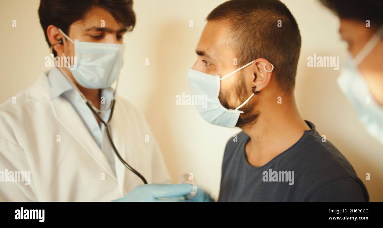 Indian doctor examining a young guy Stock Photo - Alamy