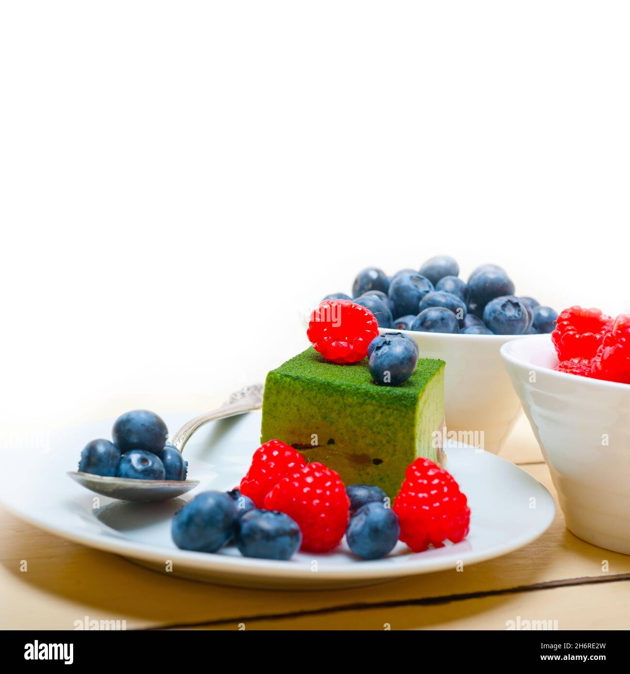 green tea matcha mousse cake with raspberries and blueberries on top ...