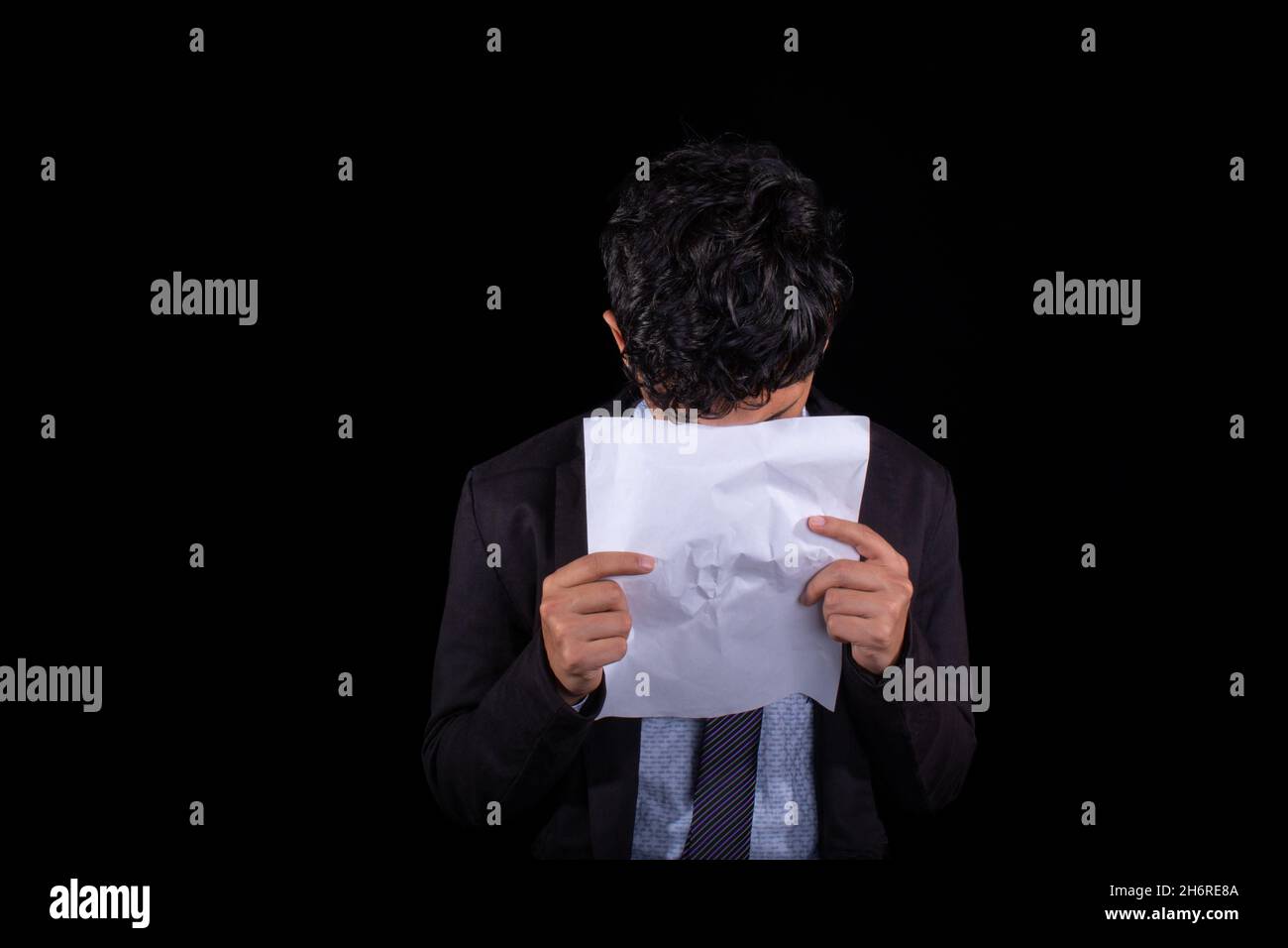 Young businessman crying over a document and covering his face ...
