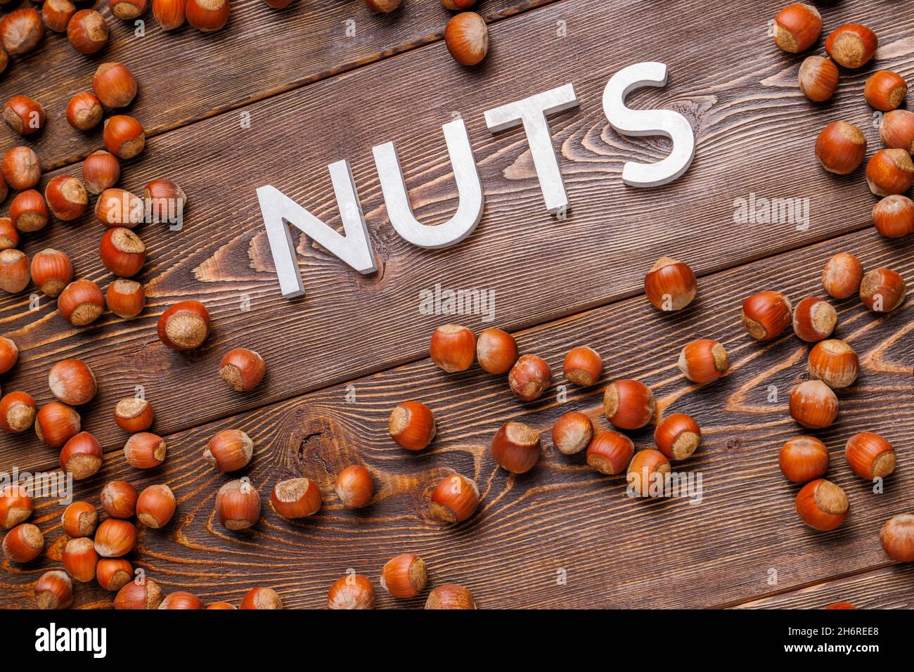 the word nuts laid with silver letters on wooden board background ...