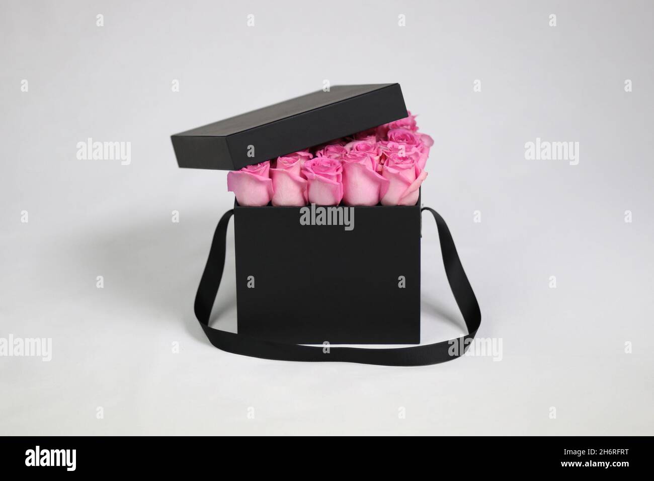 Black square gift flower box with pink roses inside. Stylish flower ...