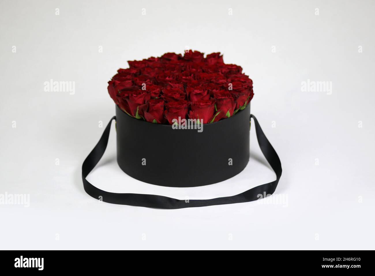 Black round gift flower box with red roses inside Stock Photo - Alamy