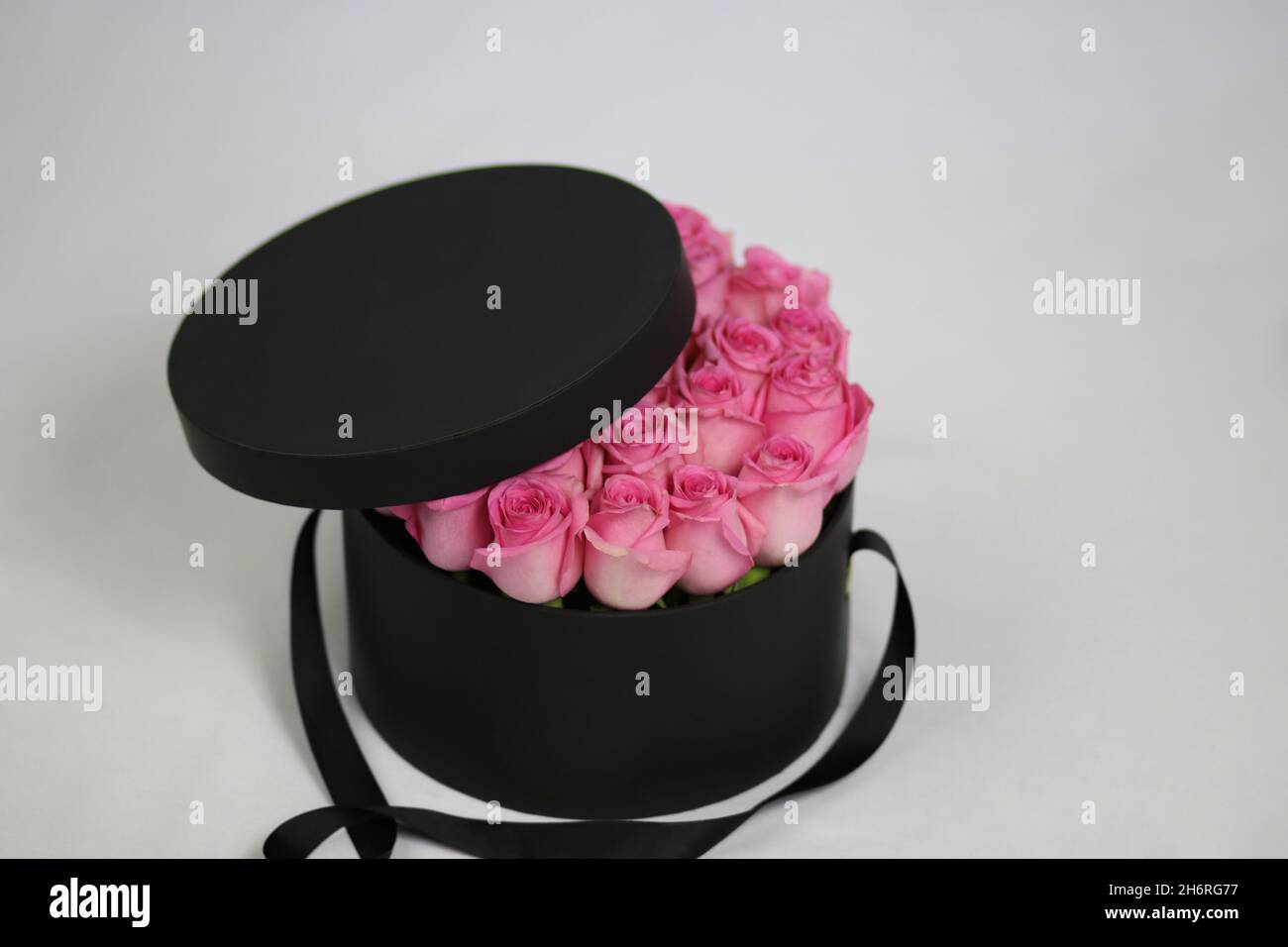Black round gift flower packaging box with pink roses inside and opened ...