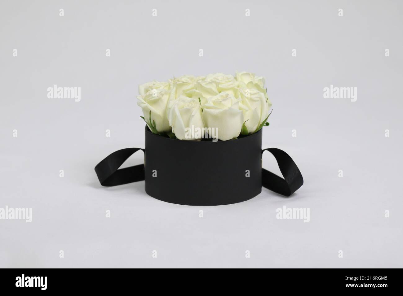 Black round gift flower box with white roses inside. Stylish flower ...