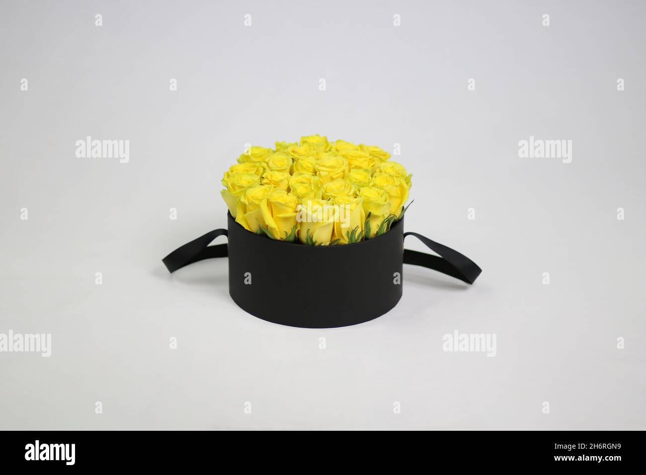 Black round gift flower box with yellow roses inside. Stylish flower ...