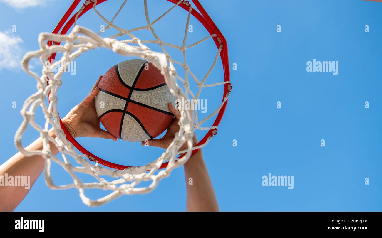 basketball ball flying through basket in players hands, copy space ...