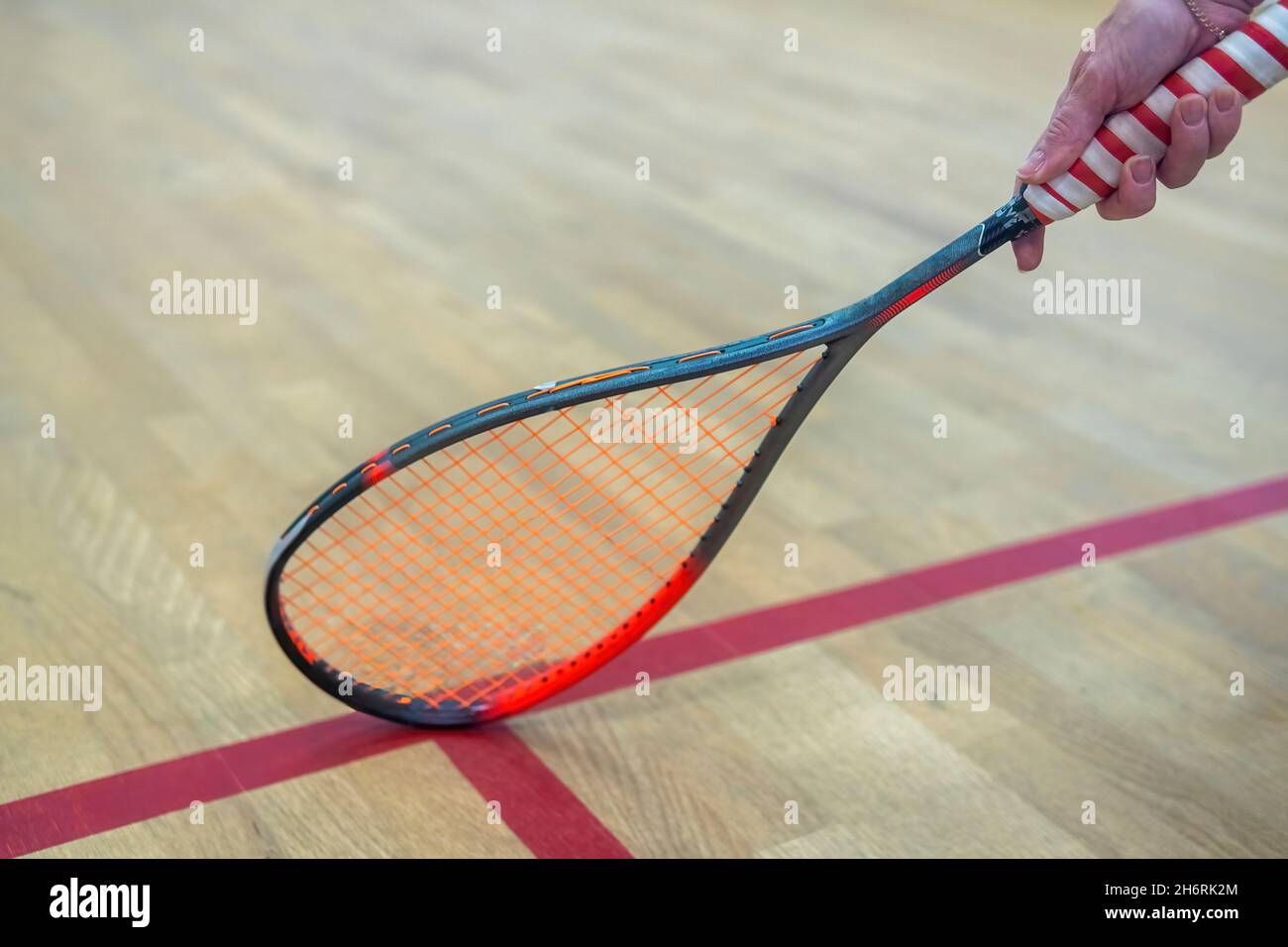 female hand holding squash racket on the line on the floor Stock Photo ...