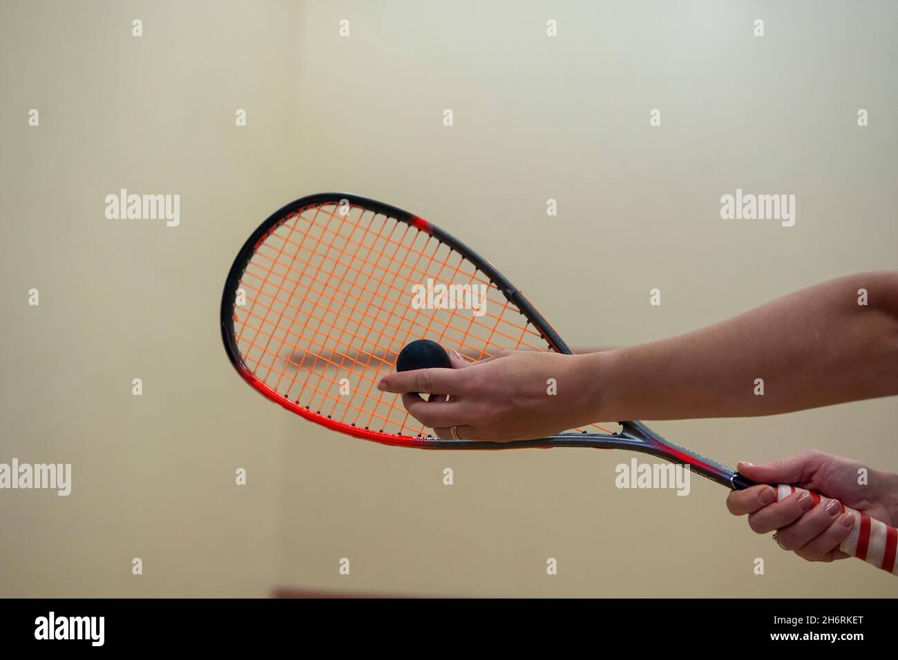 female hand holding a squash racket and hitting the ball Stock Photo ...